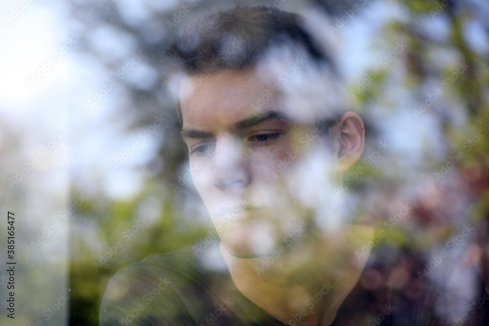 Reflecting young man behind window glass Stock Photo | Adobe Stock