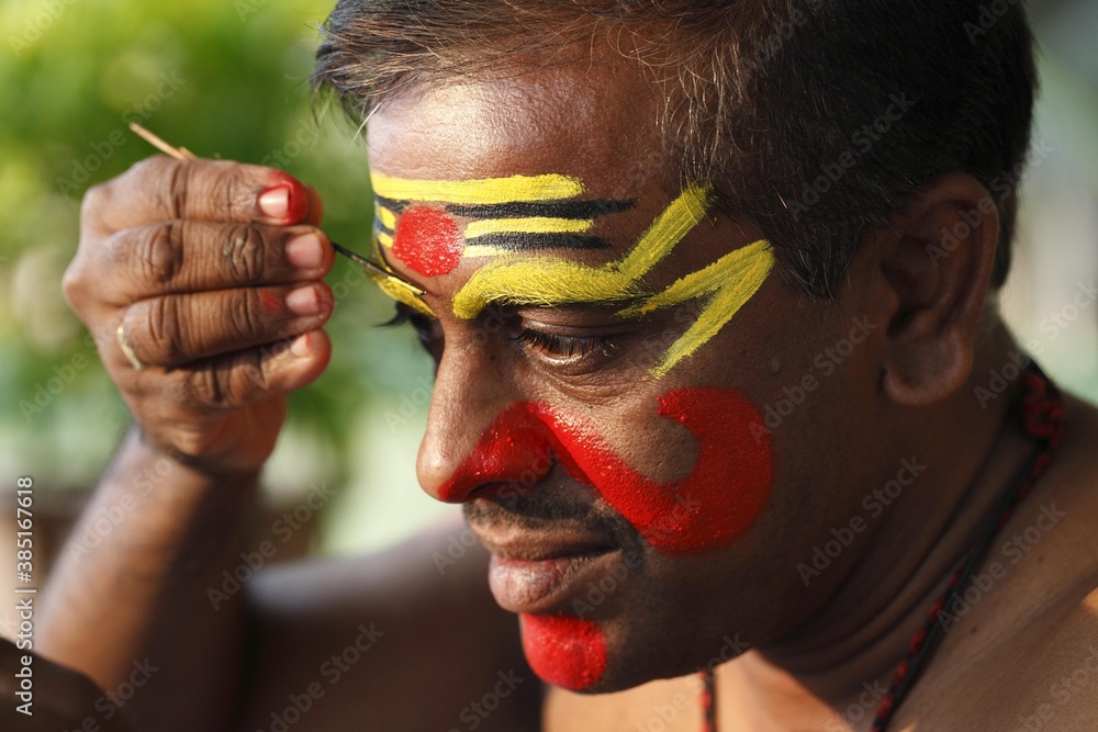Kathakali dancer doing his make up, Chuvanna Thaadi mask, Kerala ...