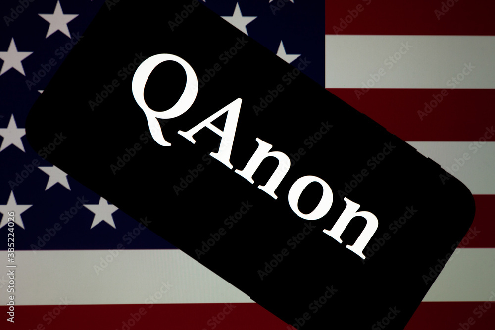 QAnon organisation logo seen on the smartphone which is placed on USA ...