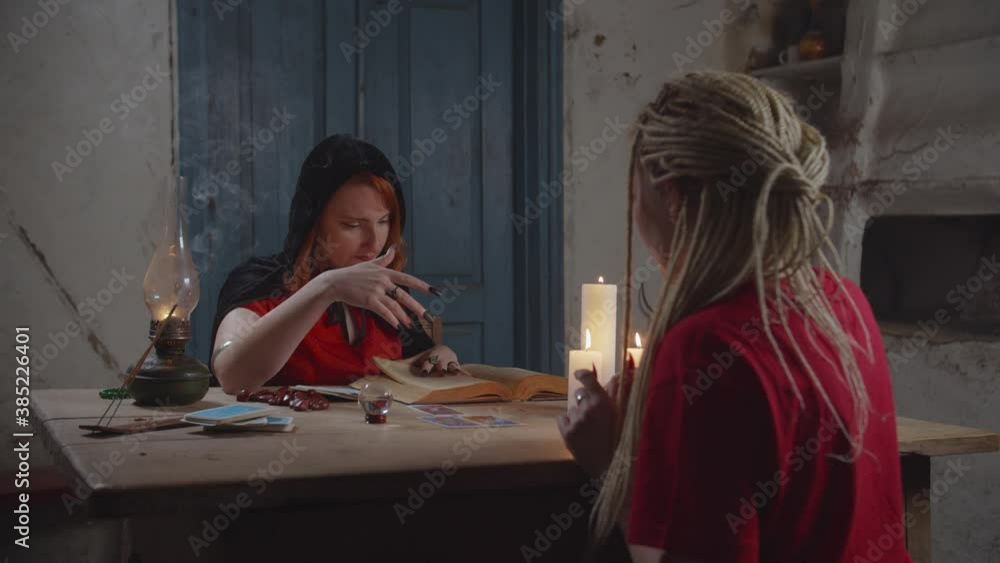 Pretty professional fortune teller with magic book tarot card reading ...
