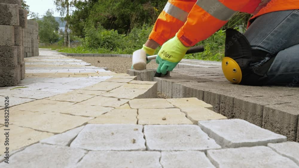 Construction work. Builder laying paving slabs on the street. Mason ...