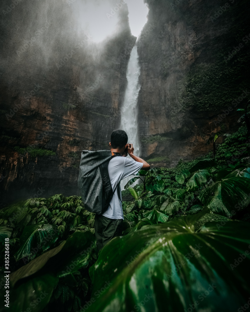 person in the forest with waterfall Stock Photo | Adobe Stock