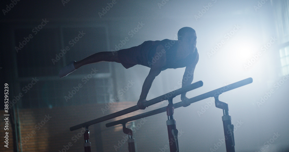Young Adult Male Athlete Gymnast Performing Routine On Parallel Bar ...