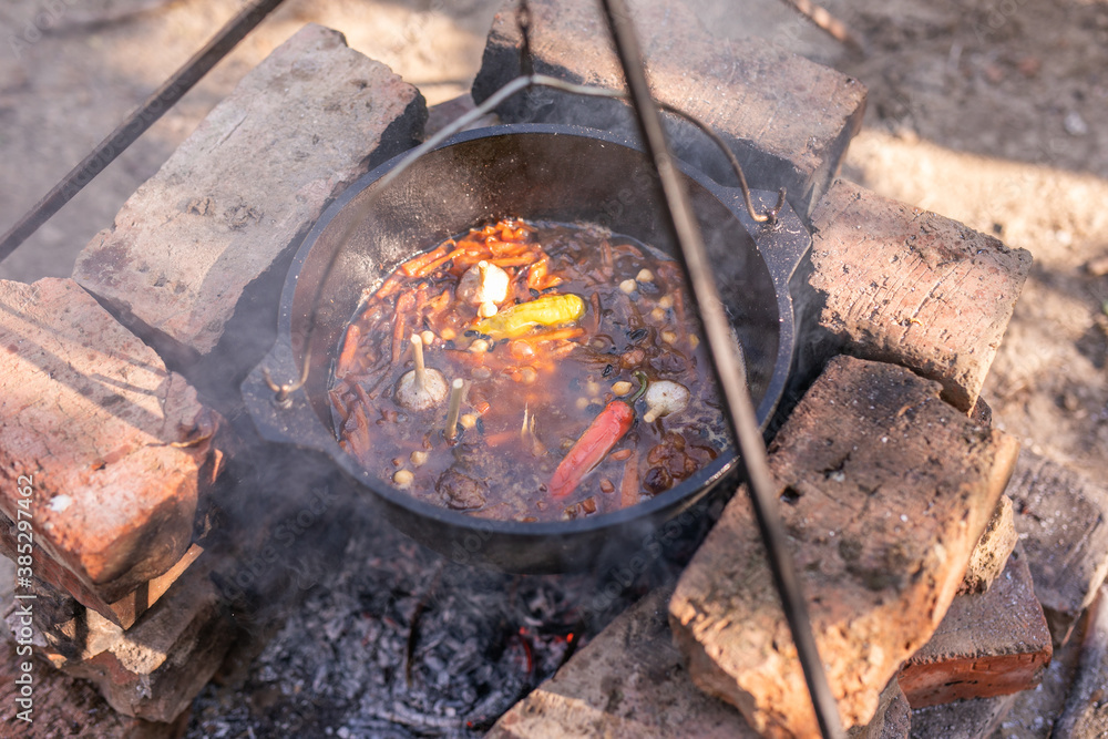 Preparation of raditional armenian pilaf in a cauldron on an open fire ...