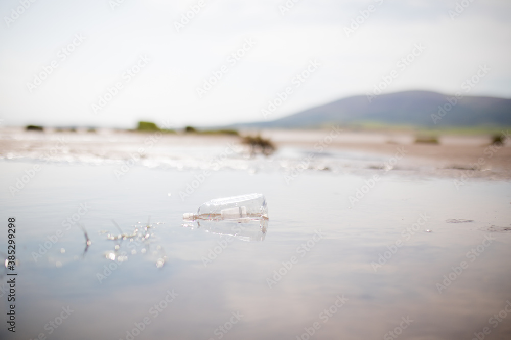 Littered Plastic Bottles Floating in a Puddle in the Middle of the Sand ...