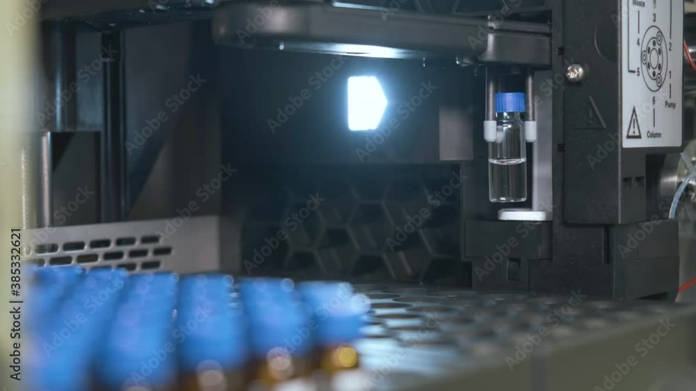 Auto sampler takes a vial and injects a sample into high performance ...