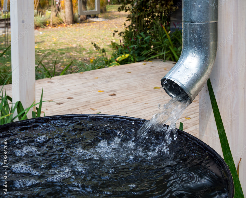 Water drains from the drain pipe into a metal container Stock Photo ...
