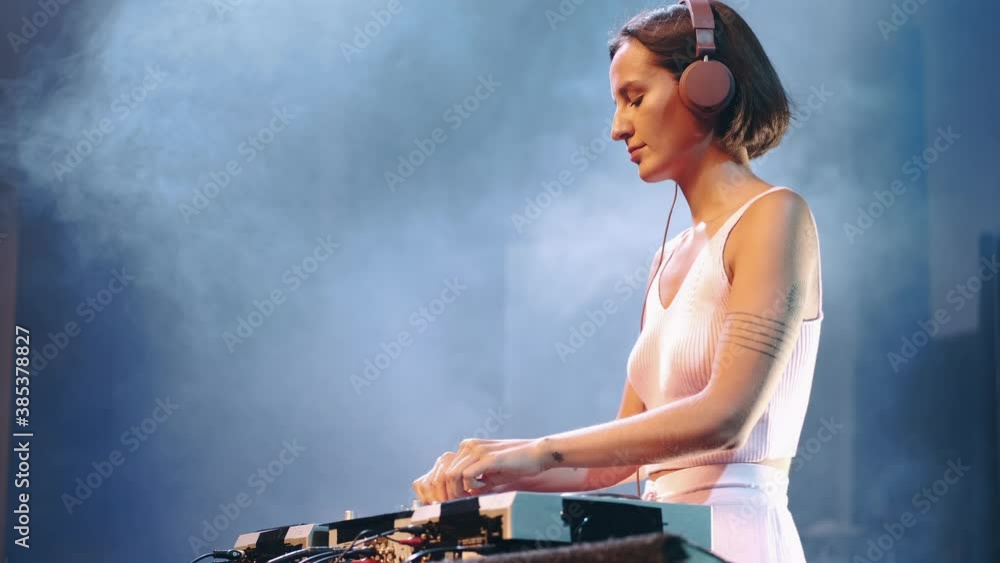 European female disc jockey working at controller, professional dj ...