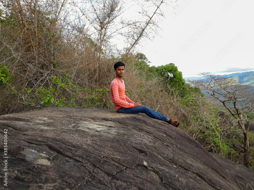 Indian boy sitting on a rock, boy sitting on the rock, young boy ...