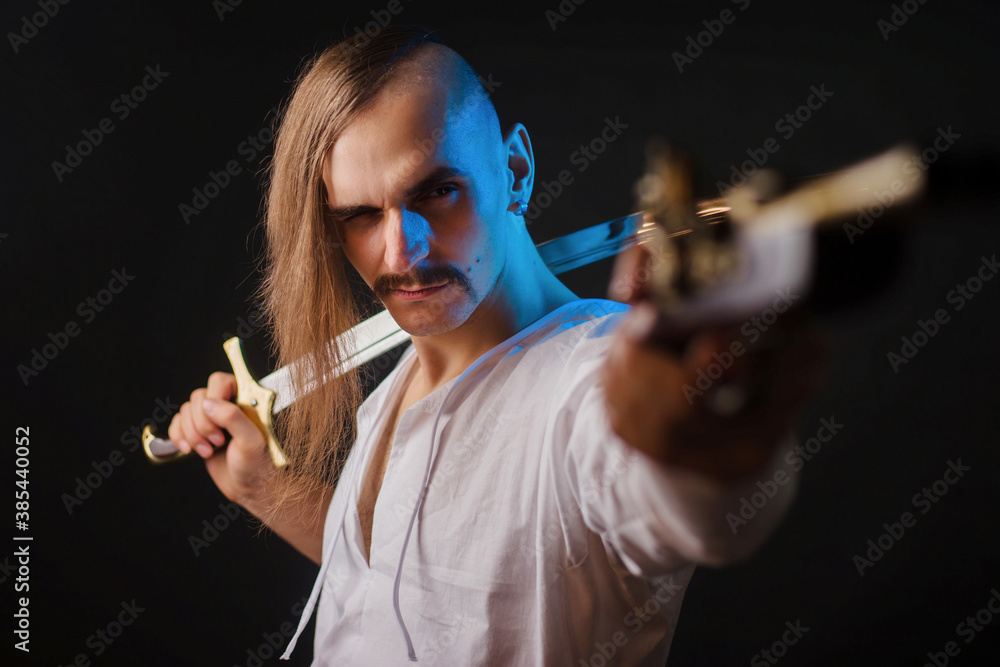 Kozak with weapons in national Ukrainian clothes. A young man with a ...
