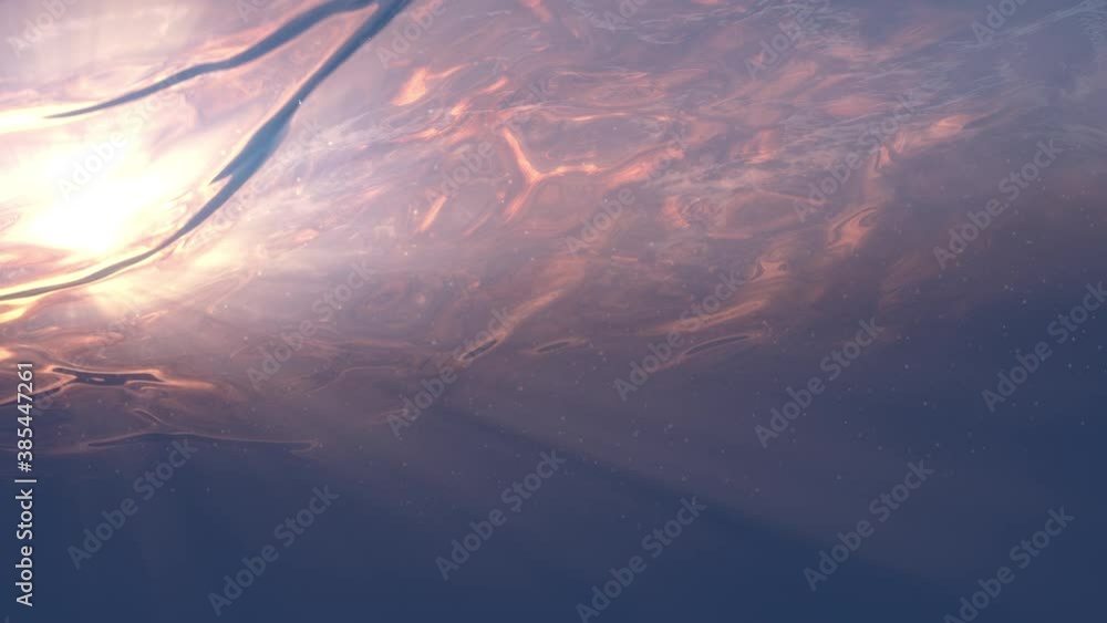 Seamless loop animation of ocean surface from underwater at sunset with ...
