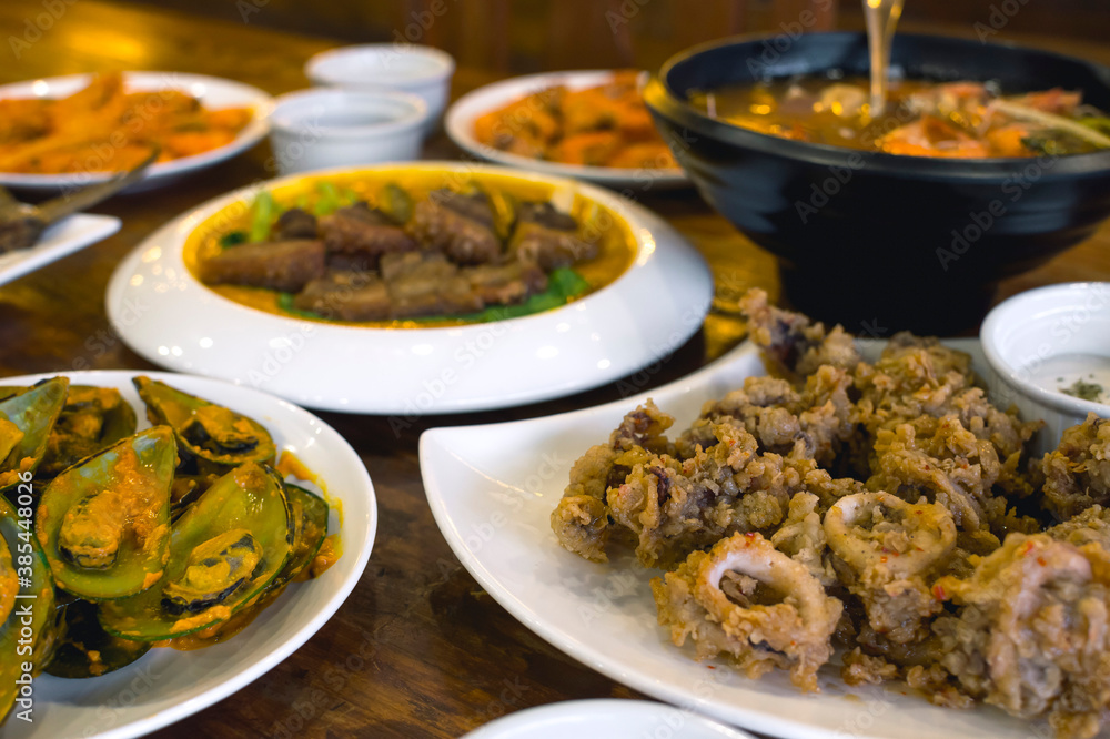 An assortment of Filipino cuisine on a wood table at a local restaurant ...