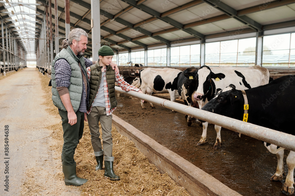 Mature bearded father embracing teenage son and telling him about care ...