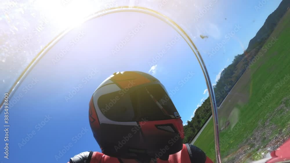 Cinematic first person view of moto race rider on a raceway. Speeding ...