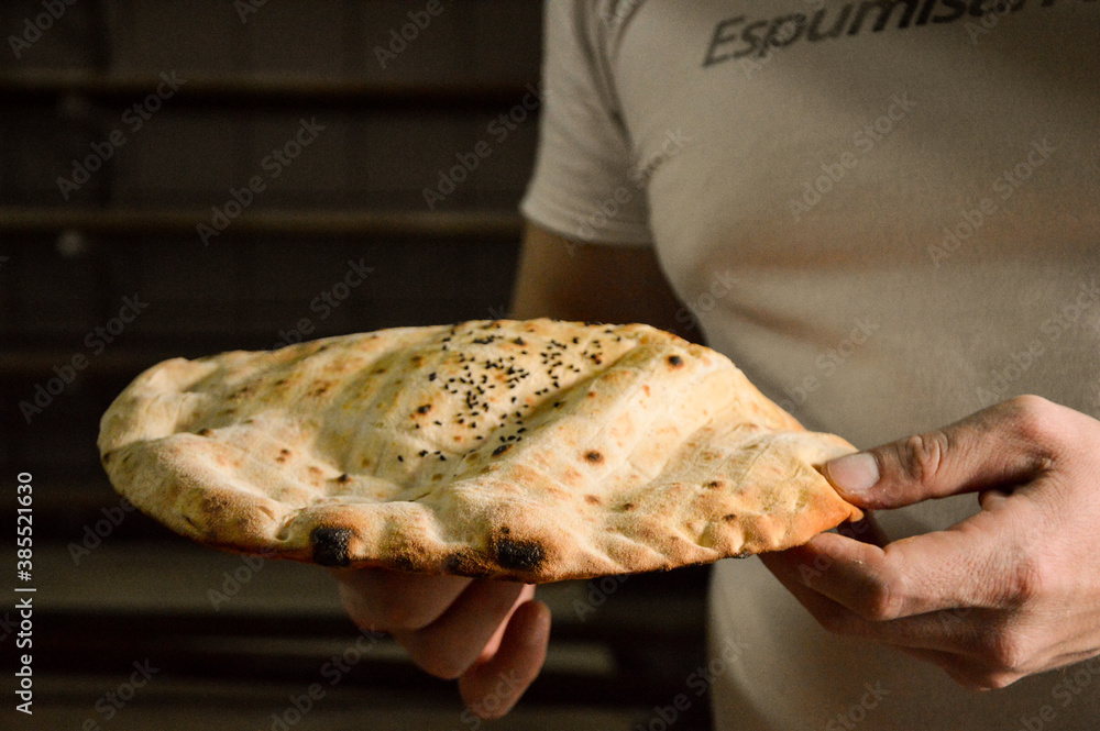 Traditional Bosnian Somun flatbread bread being prepared in a bakery in ...