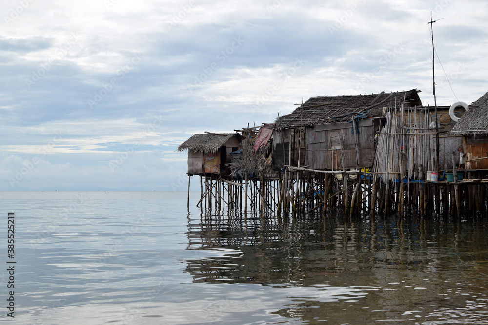 Bamboo poles support the stilt Bajau shanty houses built by indigenous ...