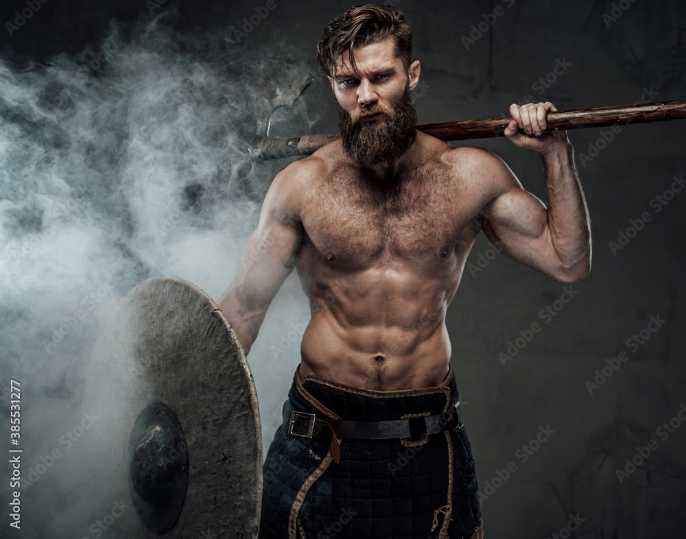 Scandinavian warrior with beard and muscular build posing holding his ...