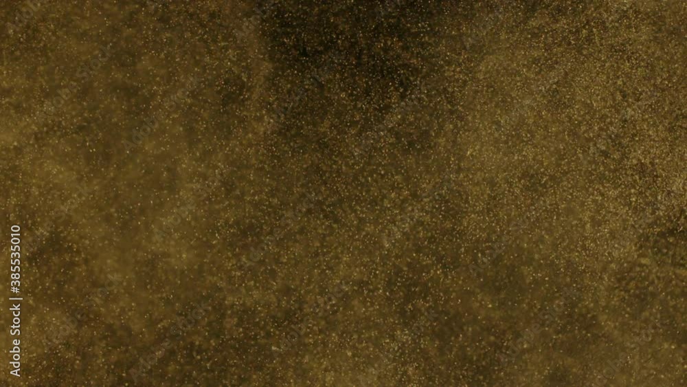 burst of flying Gold dust slow motion isolated on black backdrop ...