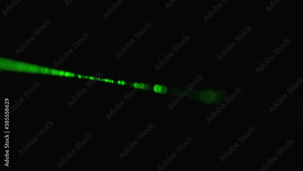 Green Laser Ray on a Black Background. Power laser beam shining in Fog ...