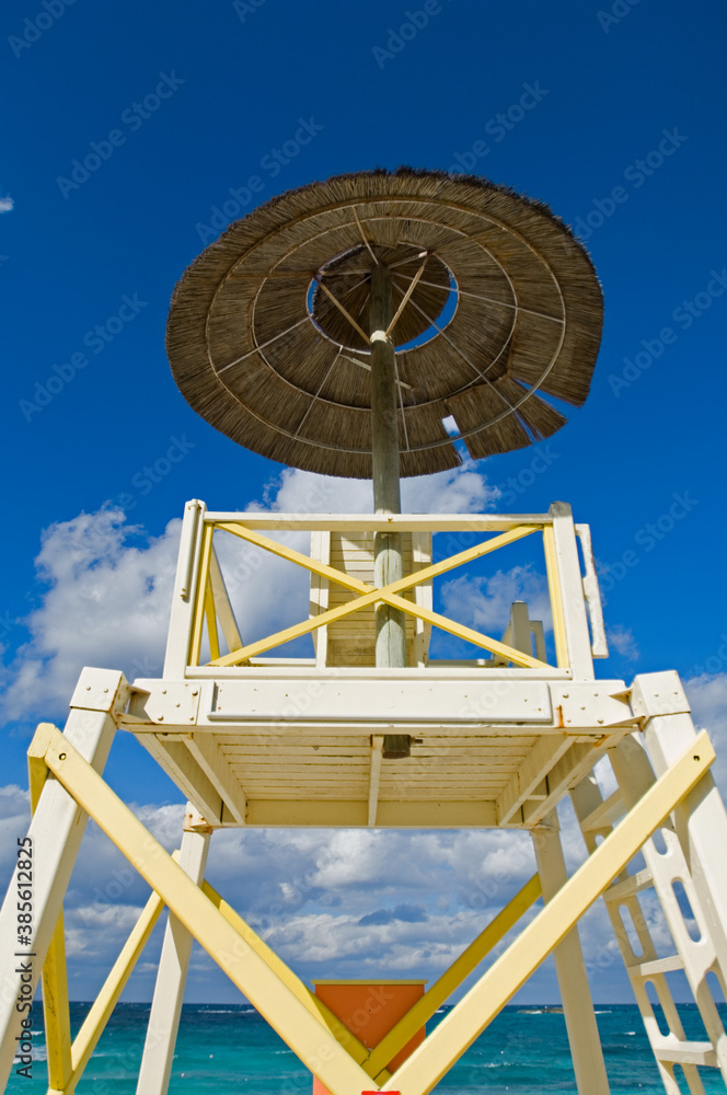 lifeguard chair with grass umbrella on a beach in paradise island ...