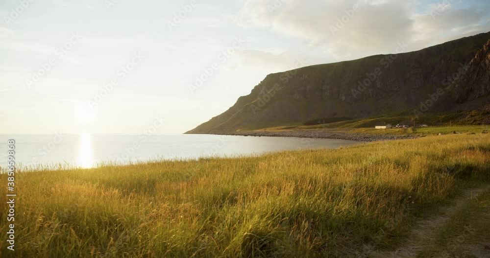 Lofoten mountain ridge and Unstad bay in golden midnight sun on Norway ...