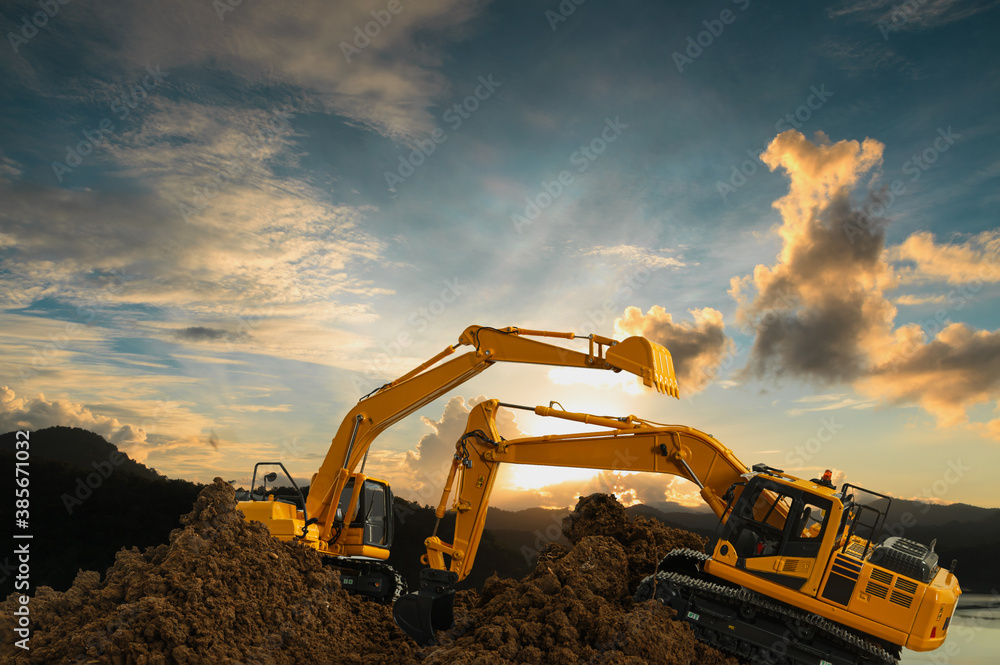 Two Excavators are digging the soil in the construction site on the ...