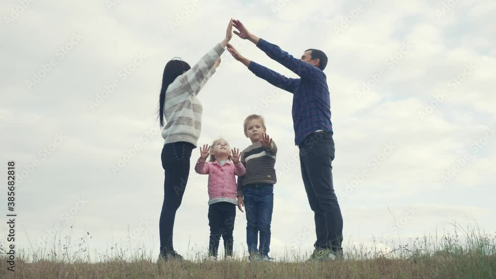 happy family. teamwork adult parents and small children shows a house ...