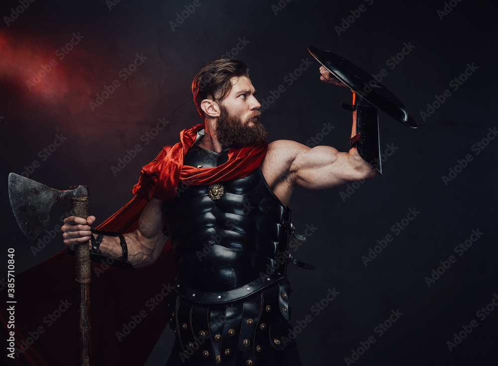 Handsome and muscular rome fighter with beard in dark armor and red ...