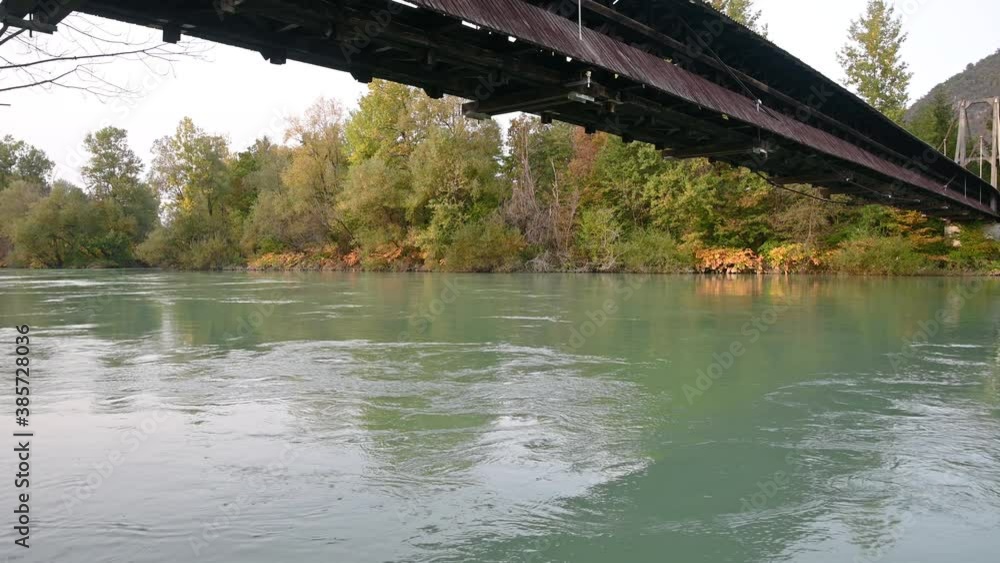 Green Sava river flows gently downstream, Slovenia. Old wooden ...