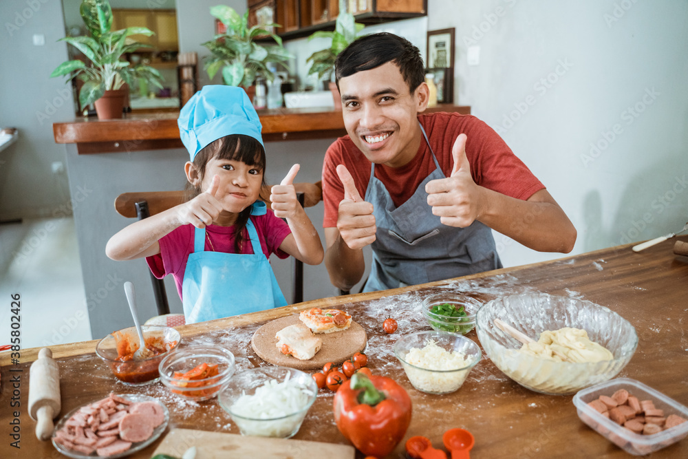Cute dad with daughter with thumbs up when eating pizza at home Stock ...