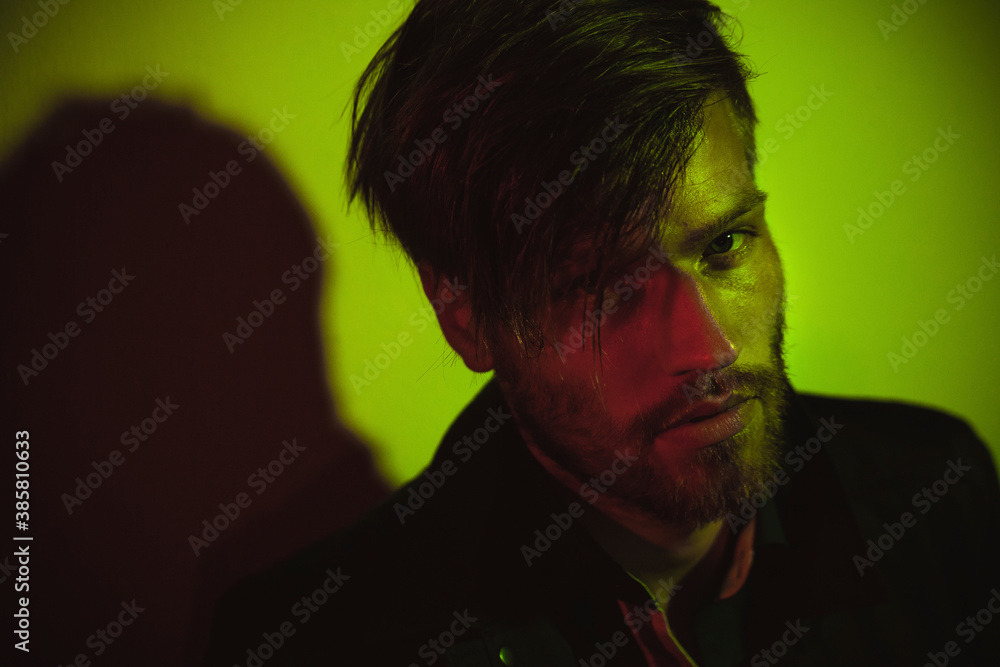 Handsome man staring standing against green background Stock Photo ...