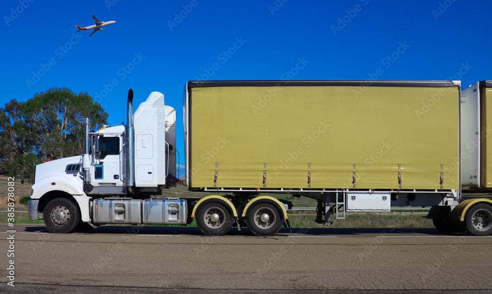 Truck on a freeway with plane flying overhead in Australian Country ...