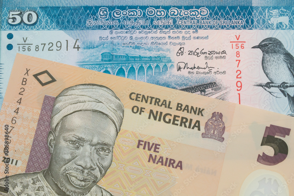 A macro image of a orange, plastic five naira note from Nigeria paired ...