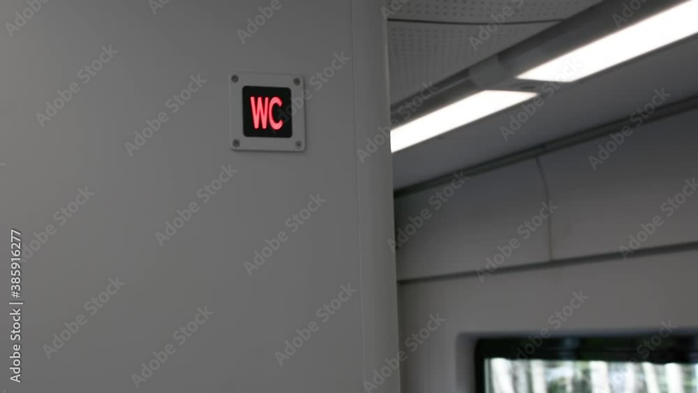 WC inscription glowing in red in the passenger carriage while the train ...