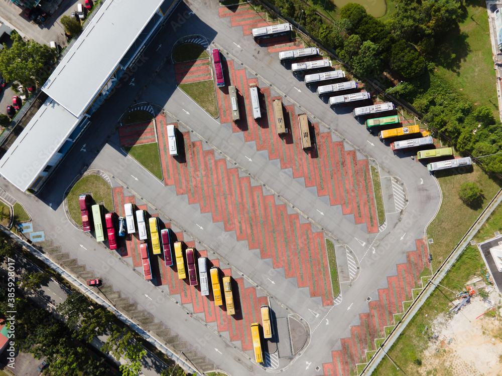 An aerial top down view of a bus depot with numbers of buses park ...