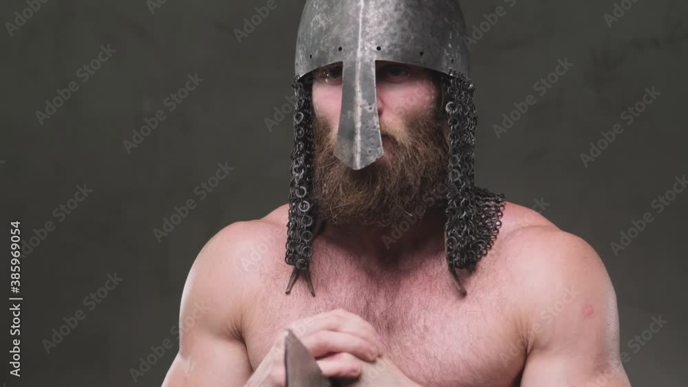 Shirtless and muscular nord barbarian with beard and helmet poses ...