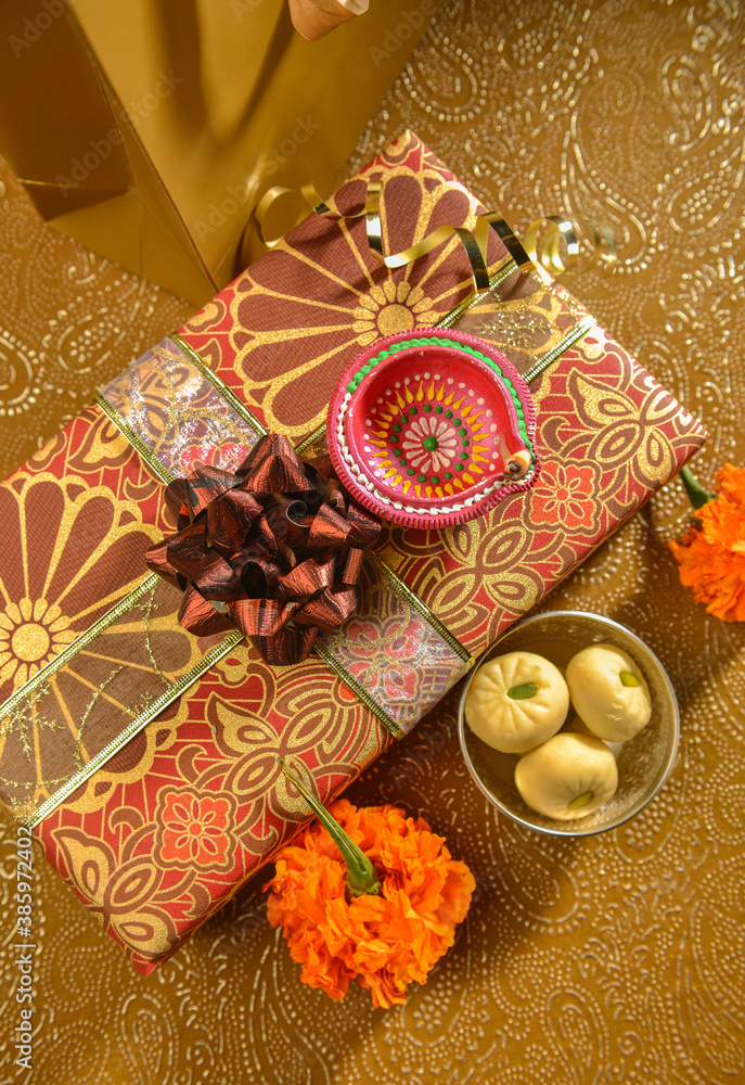 Shiny, decorative and festive gift with Indian sweet and lamp. Indian ...