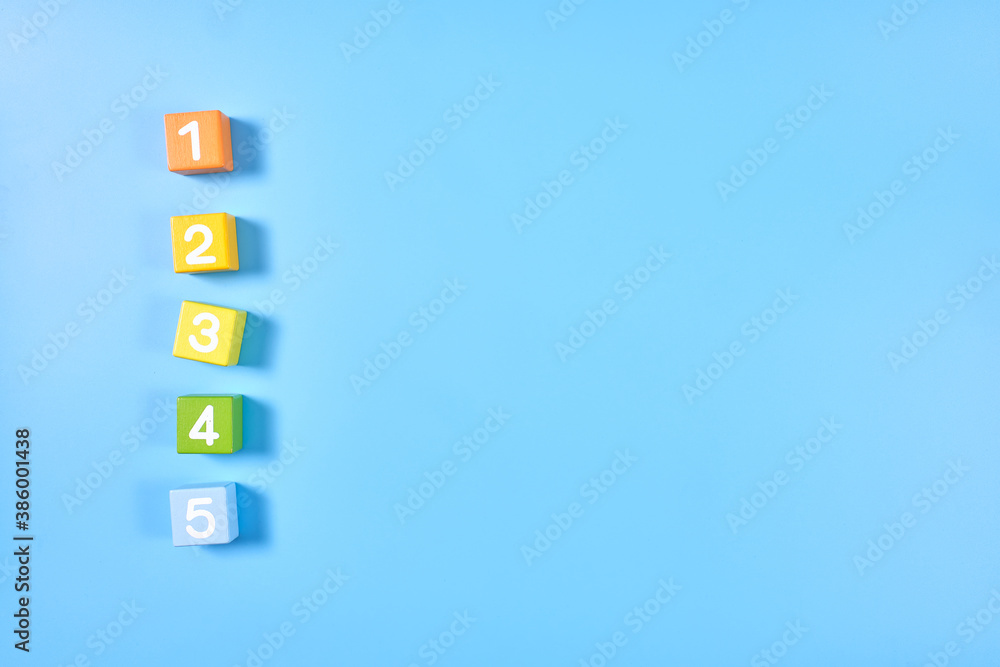 Flat lay, Top view of bright colored Numeral cubes with numbers 1 to 5 ...
