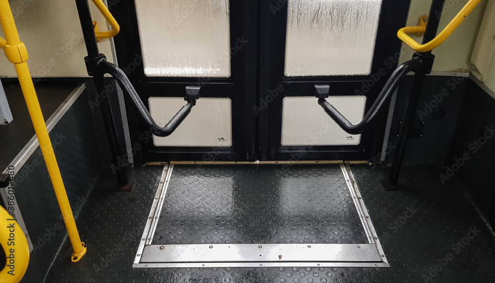 Bus door with yellow handles, interior view. The mechanism for opening ...