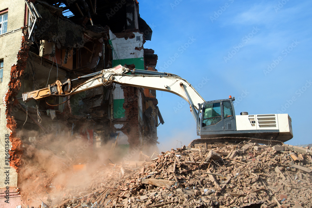 Fotka „Dismantling of an old factory by backhoe breaking concrete ...