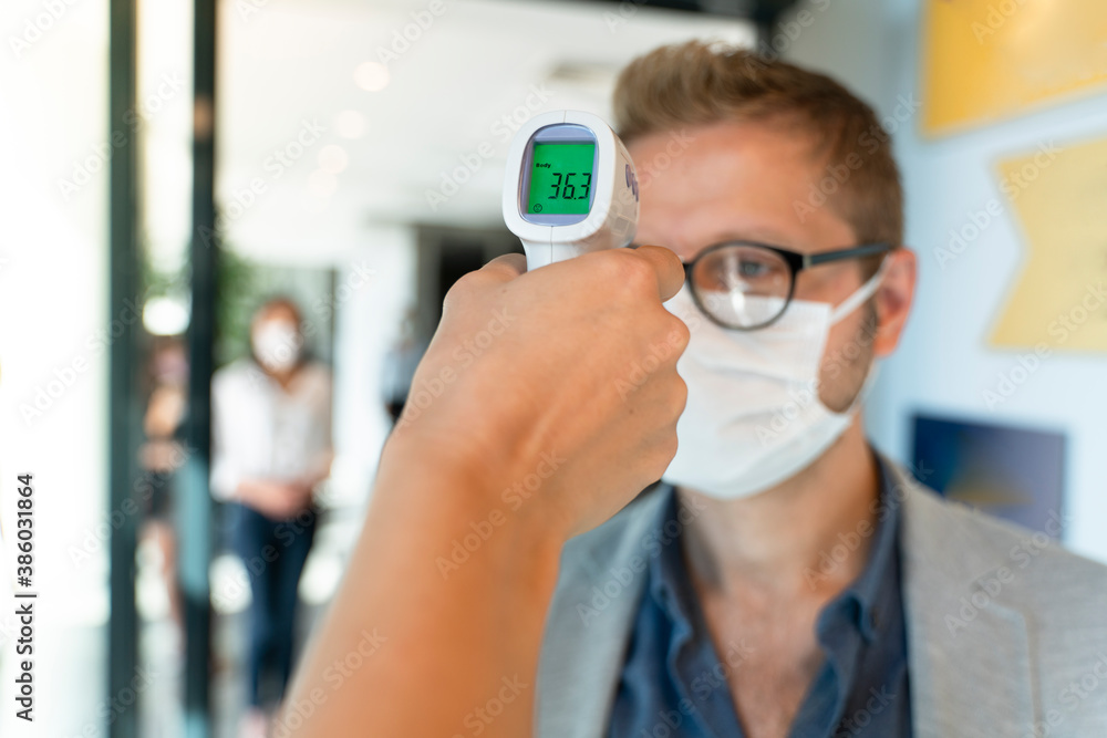 Staff check fever by digital thermometer visitor before entering the ...