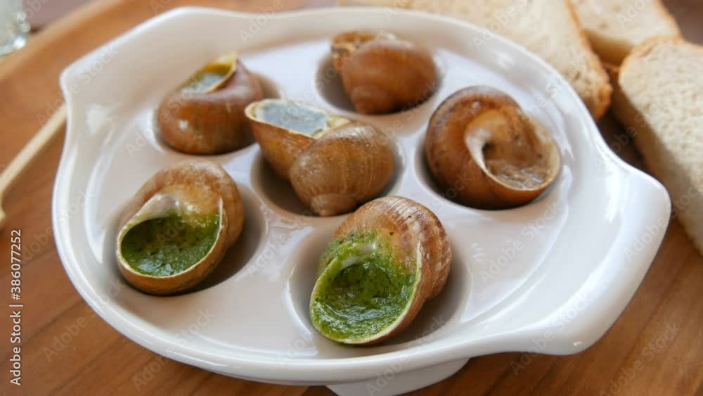 A ready made dish of snails in a sauce on a special plate in a ...