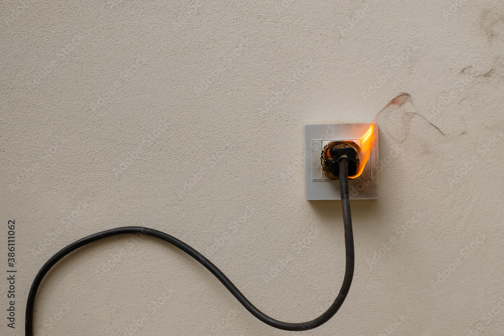 On fire electric wire plug Receptacle on the concrete wall background ...
