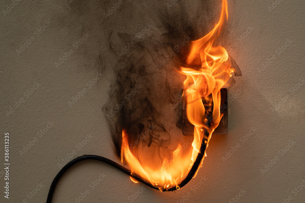On fire electric wire plug Receptacle on the concrete wall background ...
