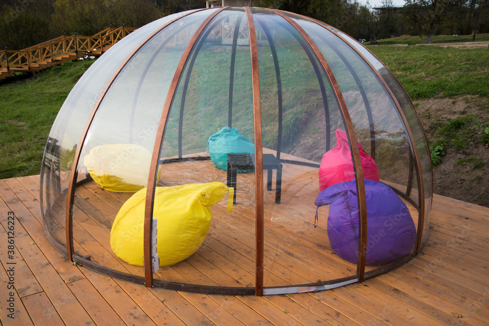 Transparent Igloo on a wooden terrace. Isolated premises for different ...