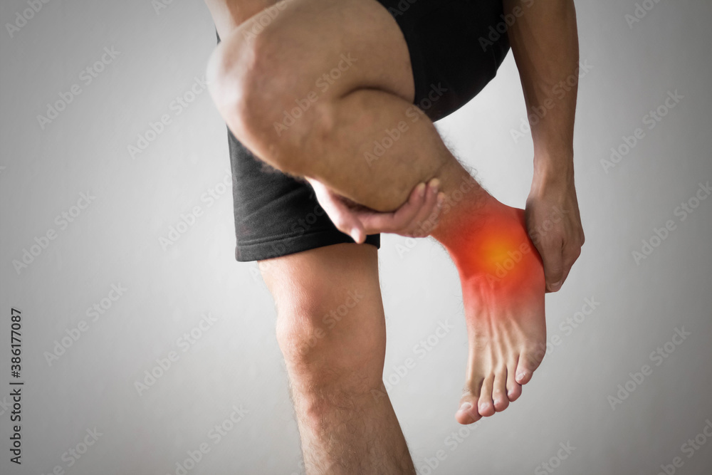 The man holds his hands to the ankle, the pain in his leg, the pain in ...