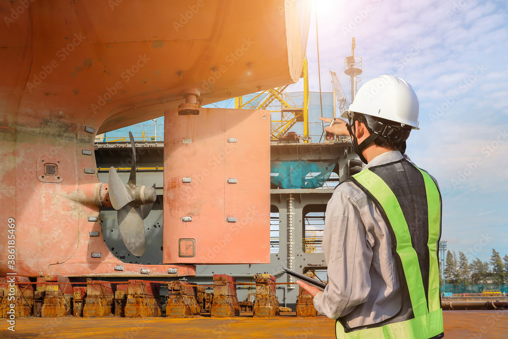 Engineer standing pointing to the target of working, Big ship under ...