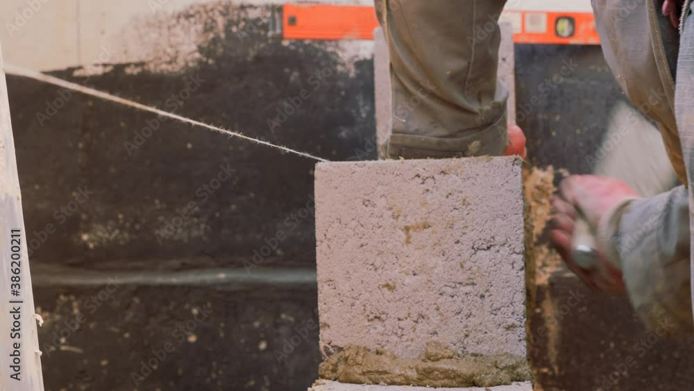 Construction work. Cinder block laying. Work of masons. Leveling the ...