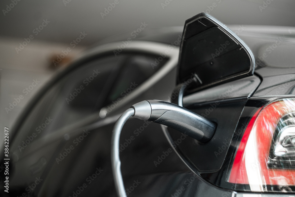 Electric Vehicle Charging Cable Plugged In Inside of Garage Stock Photo ...