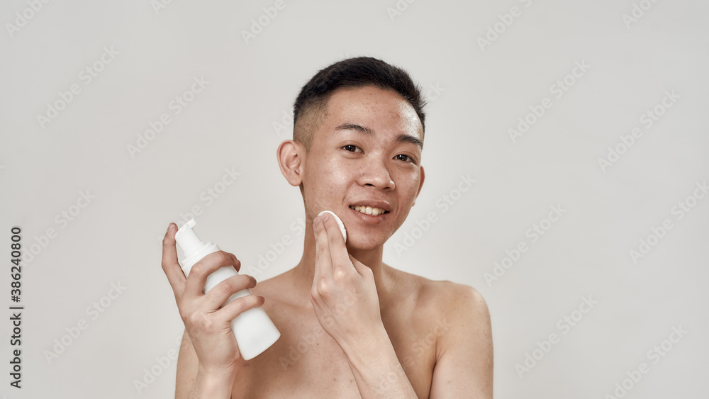 Portrait of shirtless young asian man with problematic skin cleaning ...